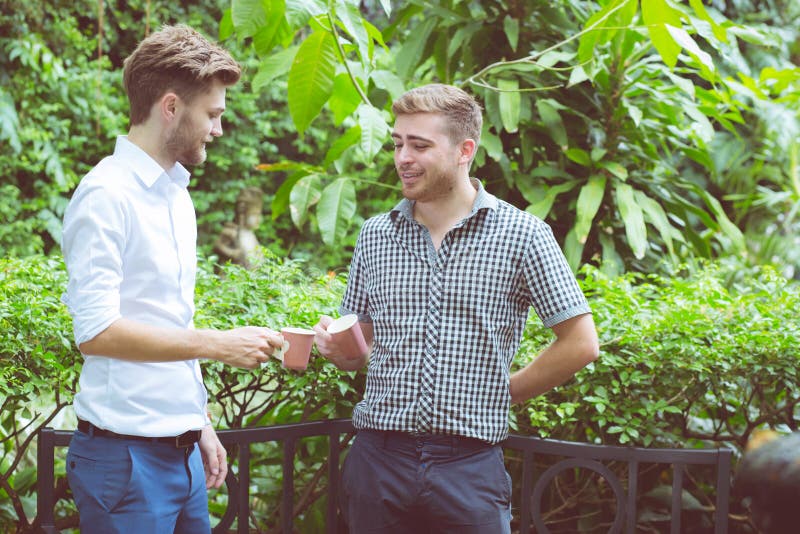 Two Friends Men Talking Standing in a Garden. Stock Image - Image of ...