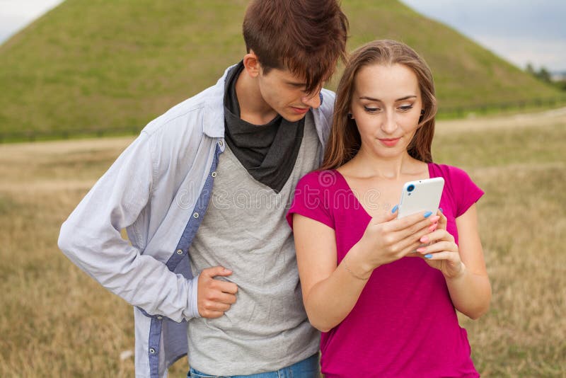 Two Friends in a Park with Mobile Phone. Summer Time. Stock Image ...