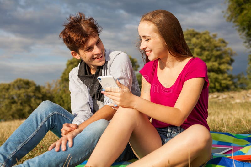 Two Friends in a Park with Mobile Phone. Summer Time. Stock Image ...
