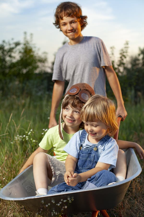 Two Friends Playing in the Plane Using a Garden Carts Stock Photo ...