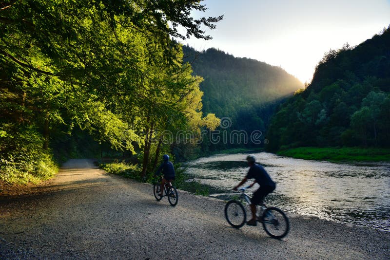 Two Friends Riding Bicycles on the River at Sunset Stock Photo - Image ...