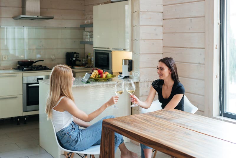 Two Friends Sitting by the Table and Drinking Wine Stock Photo - Image ...