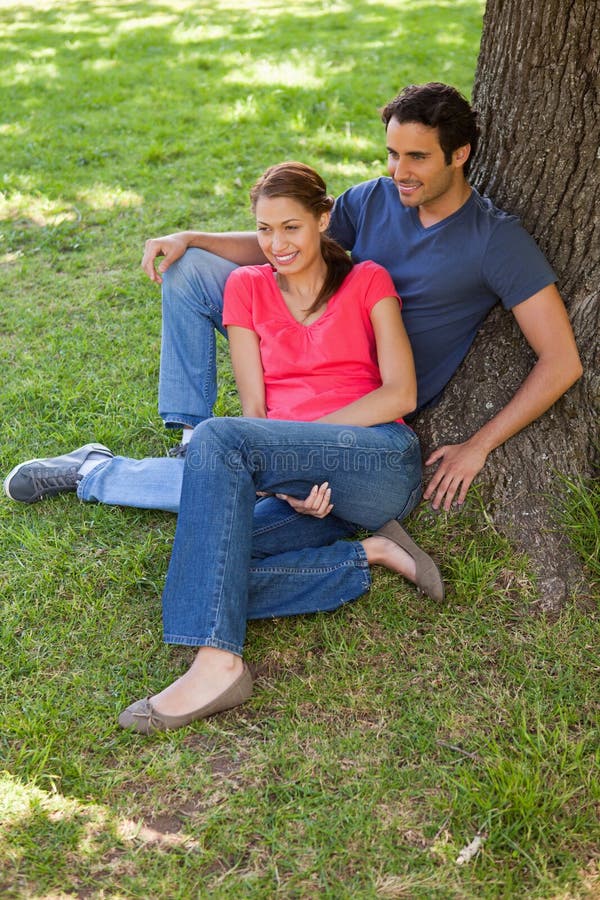 Two Friends Sitting Together Against a Tree Stock Image - Image of ...