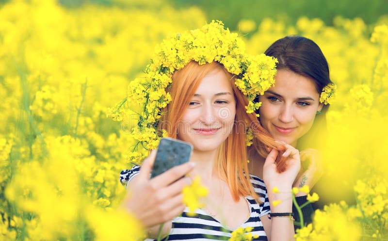 Two Friends Taking a Selfie in a Field with Yellow Flowers of Rapeseed ...
