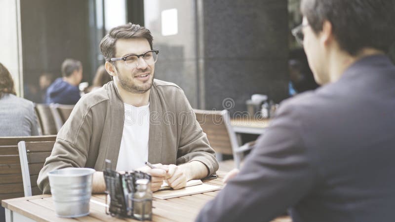 Two Friends are Talking at Table of the Cafe Outdoors Stock Image ...