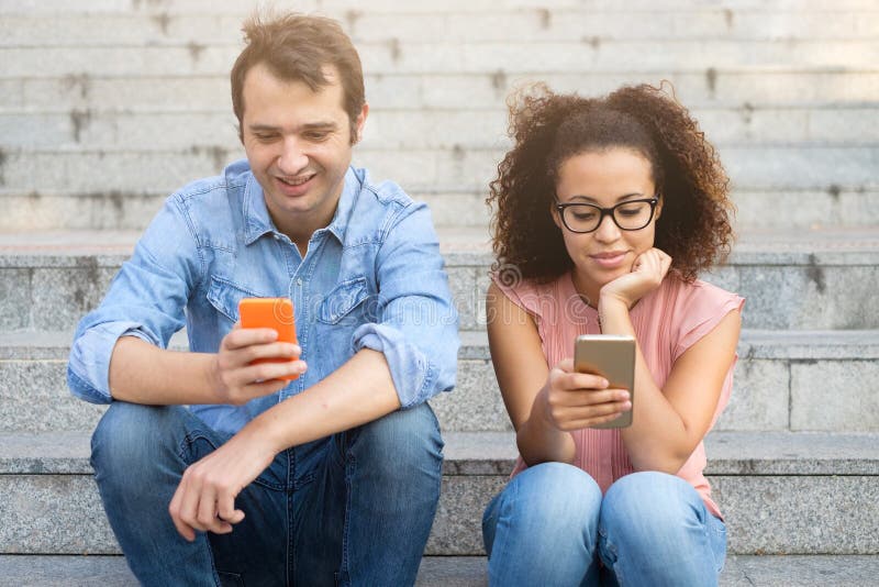 Two Friends Using Their Mobile Phones Seated Stock Photo - Image of ...