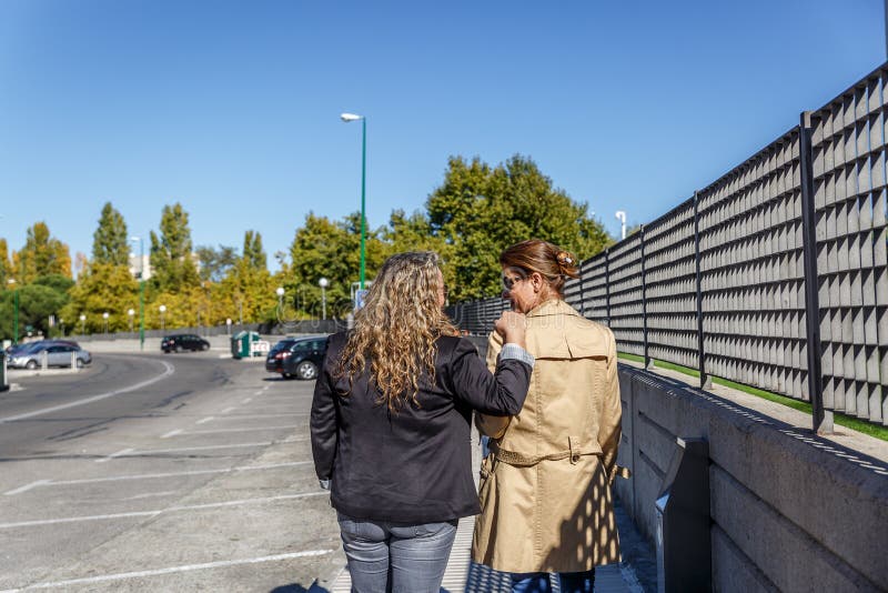 Two Friends Walk and Talk Quietly on a Sunny Day Stock Photo - Image of ...
