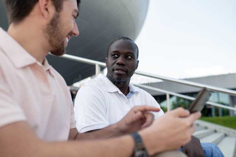 Two Friends Watching Something on the Phone and Smiling Stock Photo ...
