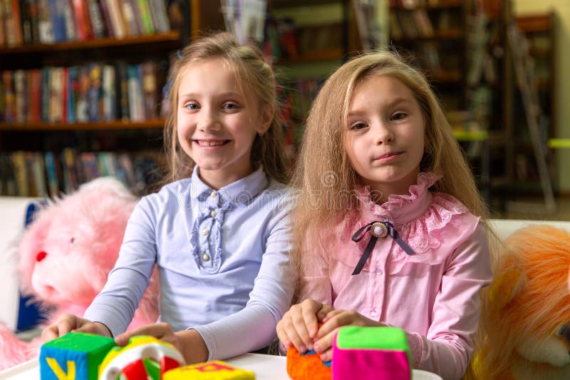 Two Funny Girls Playing with Alphabet Blocks in Library Stock Photo ...