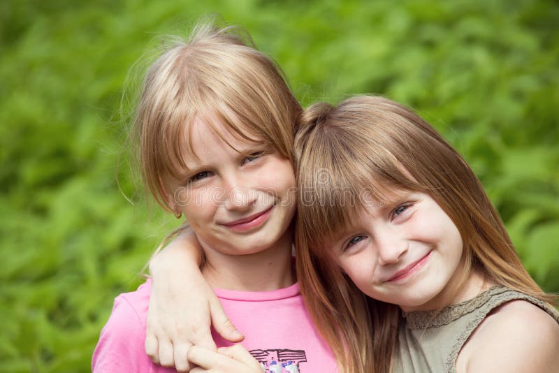 Two Cute Girls Laughing on the Grass Stock Image - Image of enjoyment ...