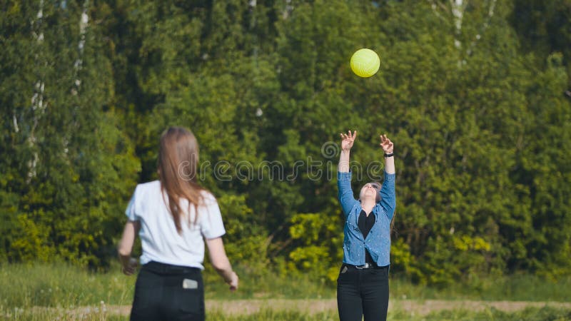 Two Girlfriends Play Volleyball in the Meadow. Stock Photo - Image of ...