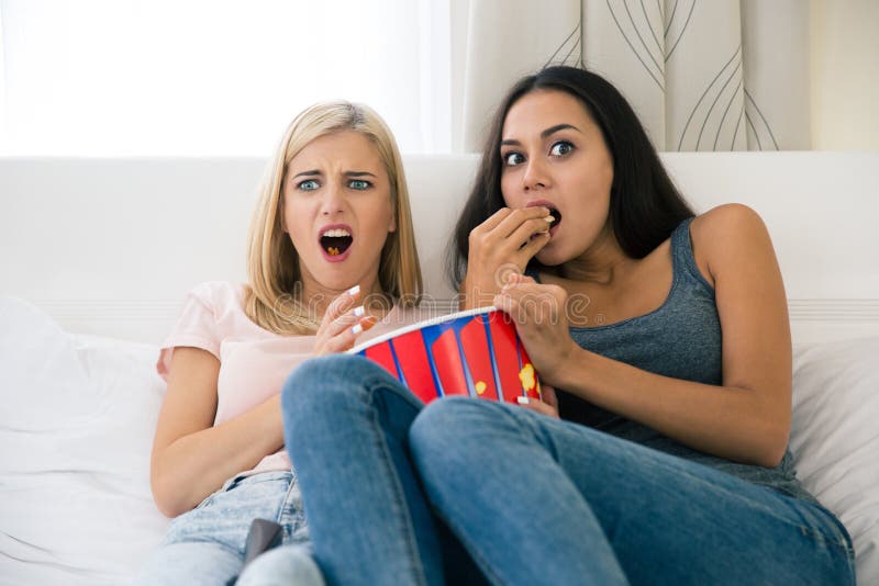 Two Girlfriends with Scared Expression Eating Popcorn Stock Photo ...