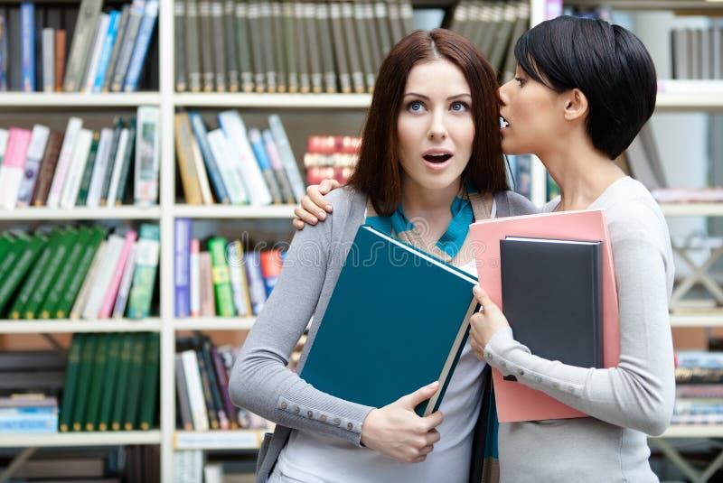 Two Girlfriends Whisper at the Library Stock Photo - Image of amazement ...