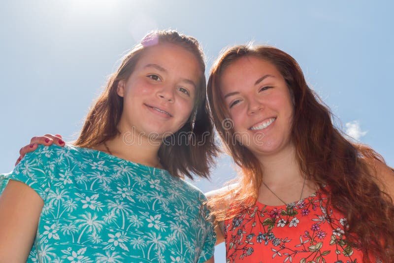 Two Girls with Blue Sky and Sunlight in the Background Stock Image ...