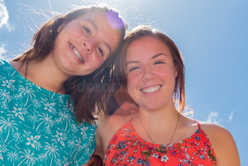 Two Girls with Blue Sky and Sunlight in the Background Stock Photo ...