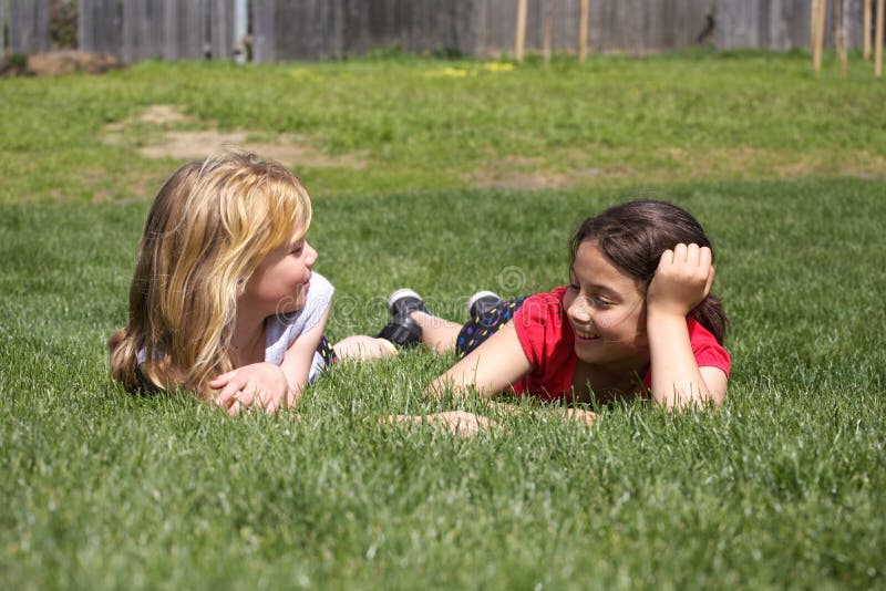 Two Girls Chatting in Grass Stock Image - Image of children, outdoor ...