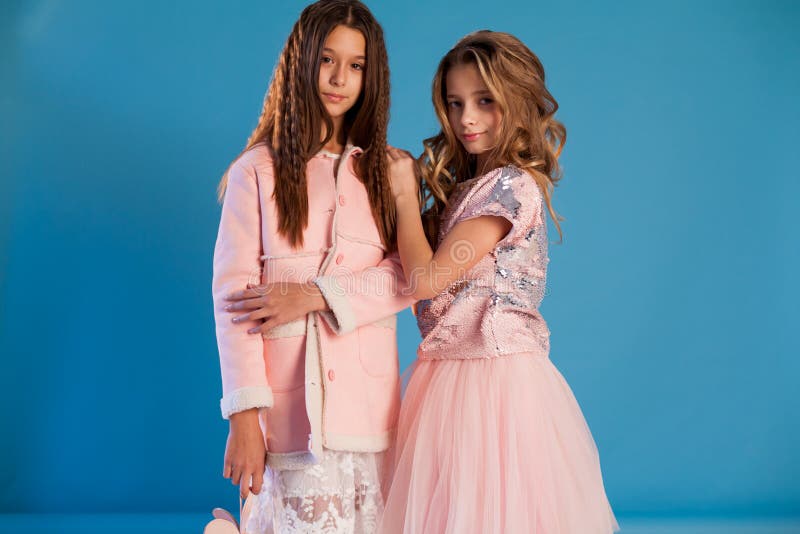 Two Girls Girlfriend in Pink Clothes on a Blue Background Stock Photo ...