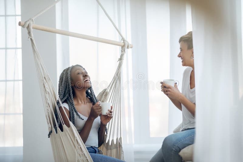 Two Girls Having Coffee in a Light Room and Talking Stock Photo - Image ...
