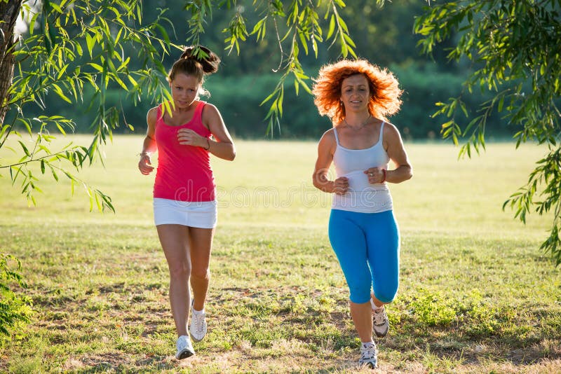Two girls jogging stock photo. Image of freedom, grass - 32973434