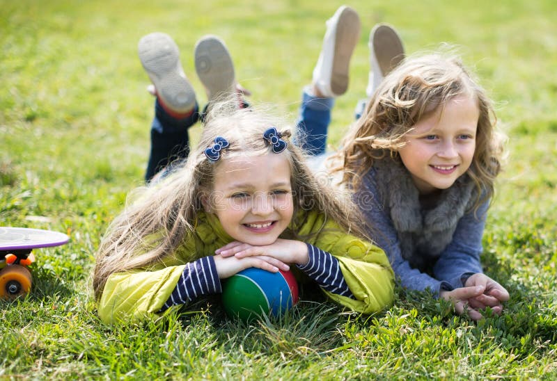 Two girls lie on grass stock photo. Image of females - 102842608