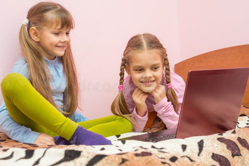Two Girls Looking at Laptop and Laughing Merrily, One is Pointing at ...