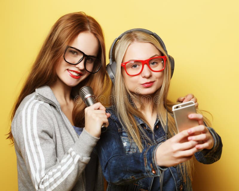 Two Young Girls Singing Over Yellow Background Stock Image - Image of ...