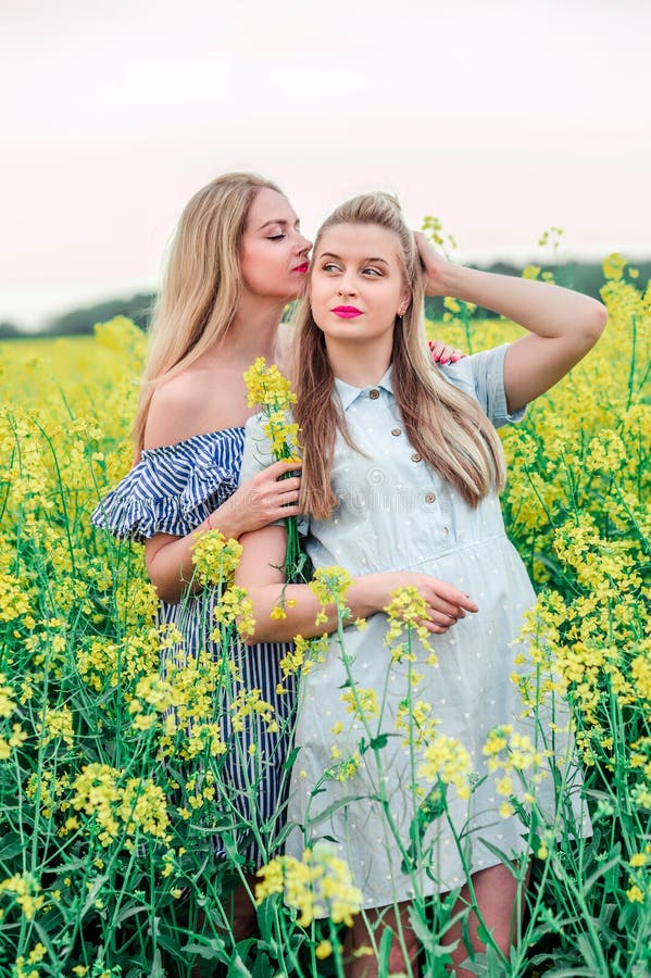 Two Girls Models Posing Together on Camera in the Rapeseed Field Stock ...