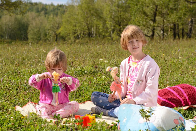 Two girls play with dolls stock photo. Image of grass - 58151804
