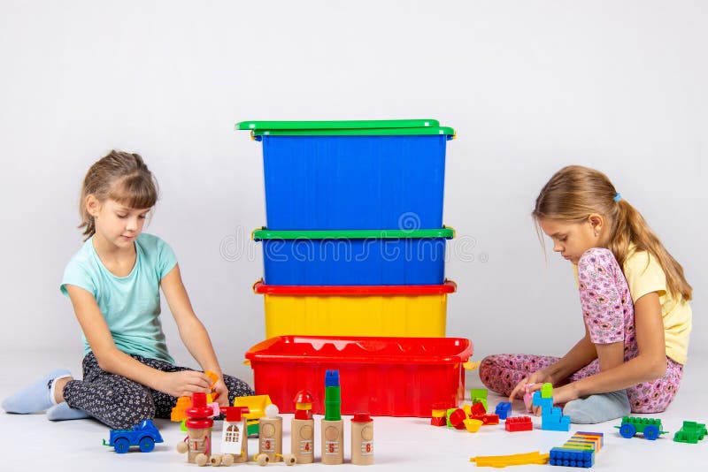 Two Girls Play Toys, in the Middle are Boxes with Toys Stock Photo ...