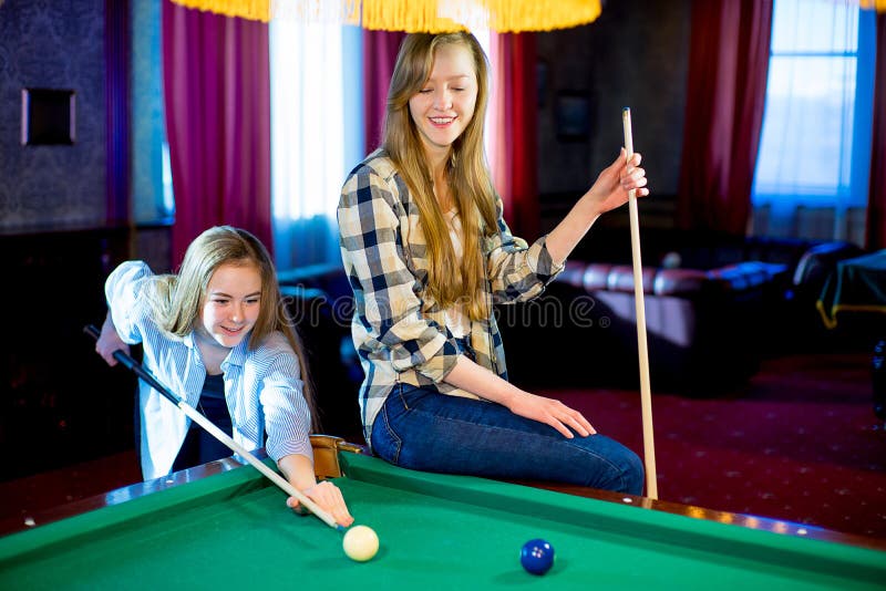 Two girls playing billiard stock photo. Image of nightlife - 85957568