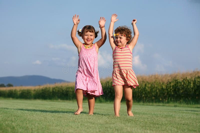Two girls playing outdoors stock image. Image of field - 12784117