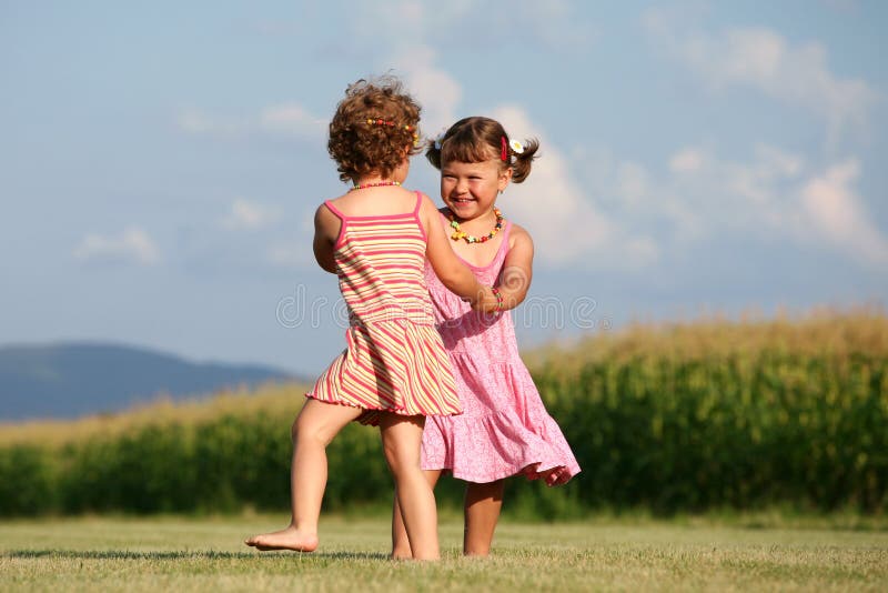 Two girls playing outdoors stock image. Image of field - 12784117