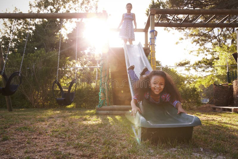 Two Girls Playing Outdoors at Home on Garden Slide Stock Photo - Image ...