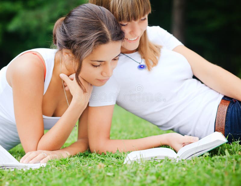 Two girls reading a book stock image. Image of face, grass - 10605255