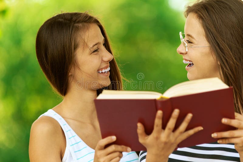 Two girls reading book stock photo. Image of green, book - 24993924