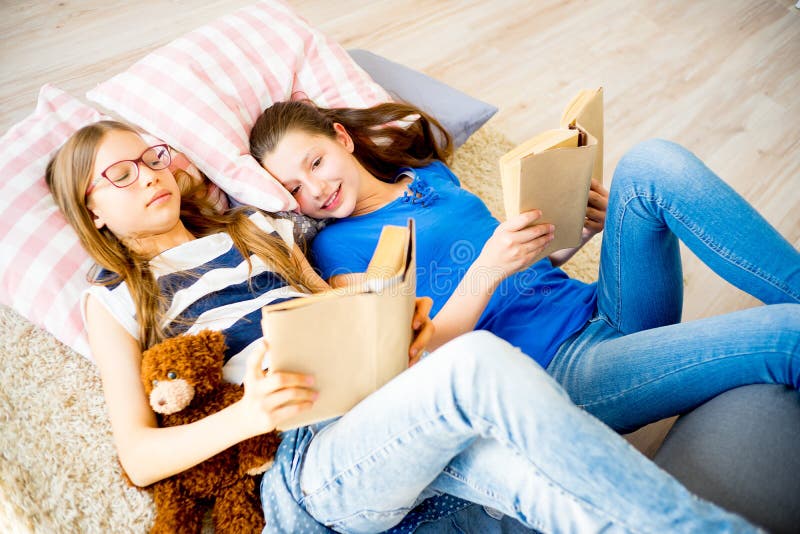 Two girls reading books stock image. Image of living - 99289573