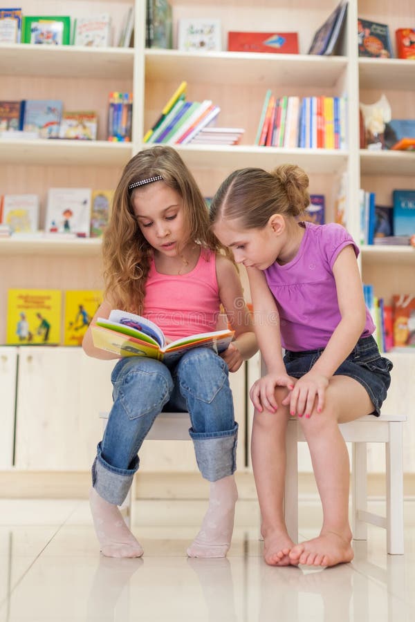 Two Girls Reading a Book in the Library and Laugh Stock Image - Image ...