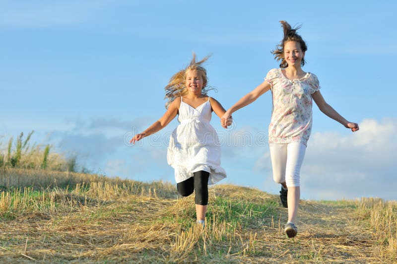 Two Girls Running Across the Field Stock Photo - Image of happiness ...