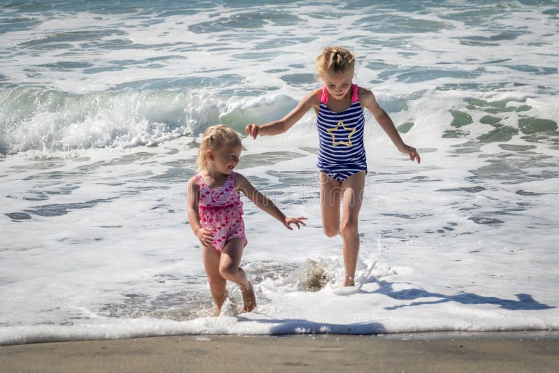 Two Girls Running Away from Ocean Waves Stock Image - Image of water ...