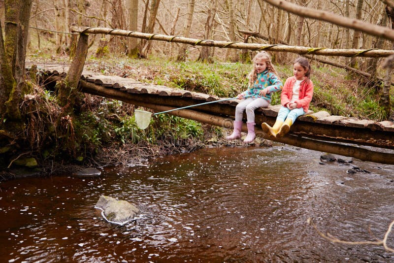 Two Girls Sitting on Bridge Fishing in Stream with Net Stock Image ...