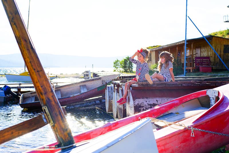 Two Girls Sitting on the Dock Stock Image - Image of looking, outdoors ...