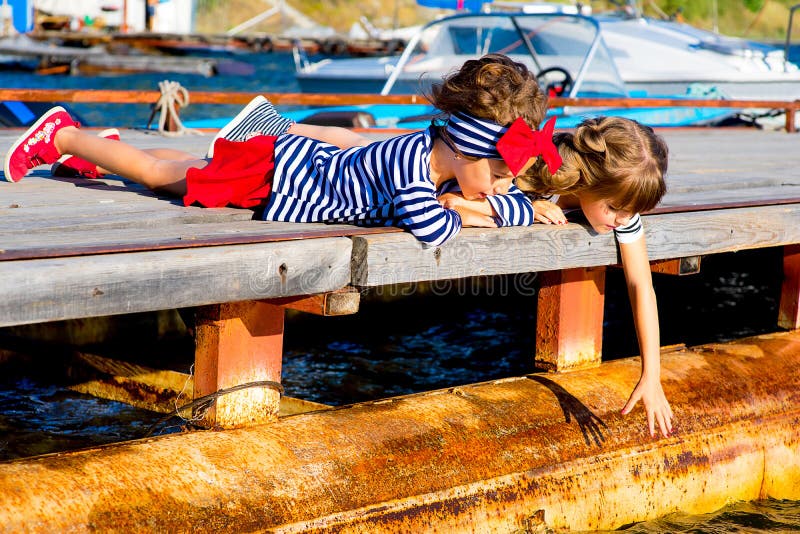 Two Girls Sitting on the Dock Stock Photo - Image of holiday, laugh ...