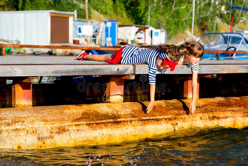 Two Girls Sitting on the Dock Stock Photo - Image of children, holiday ...