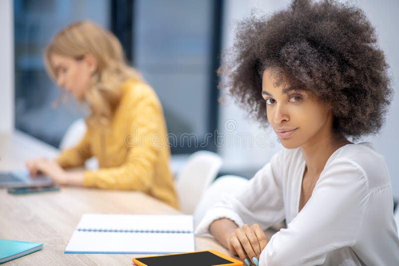 Two Girls Sitting at the Tables in the Office and Looking Busy Stock ...