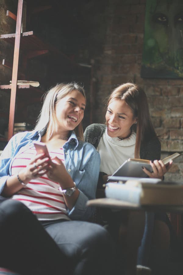 Two Girls Students Having Conversation and Using Mobile Phone. Stock ...