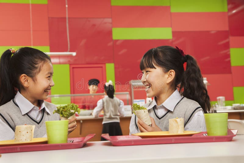 Two Girls Talking at Lunch in School Cafeteria Stock Image - Image of ...