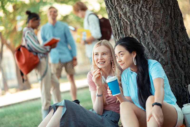 Two Girls Talking about Their Groupmates in the Front. Stock Image ...