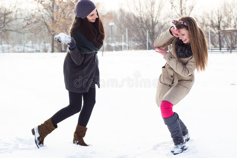 Two Girls Throwing Snow-balls Stock Image - Image of scarf, joyful ...