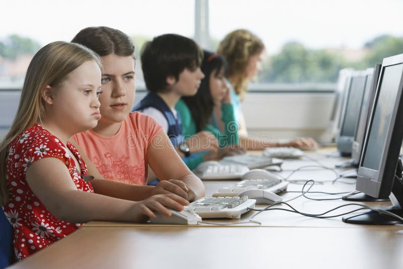 Two Girls (10-12) Using Computer in Computer Lab Children in Background ...