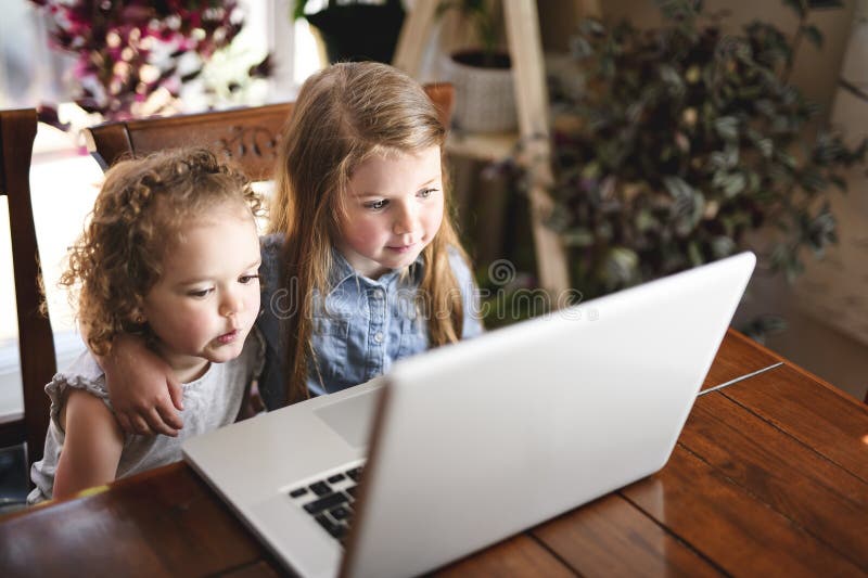 Two Girls Using Laptop on the Kitchen Table Stock Image - Image of ...